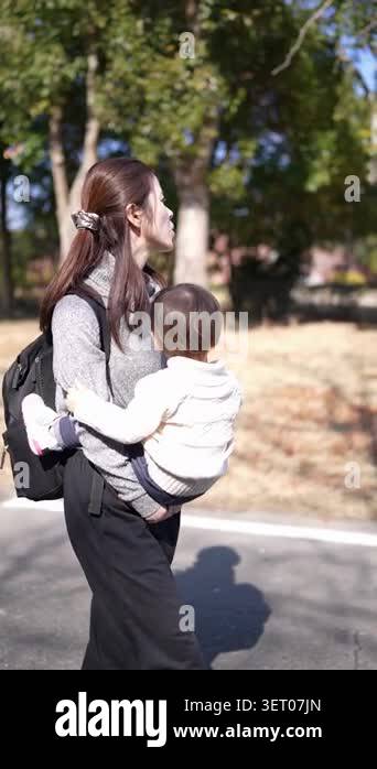 Woman carrying child while walking outdoors Stock Video Footage - Alamy