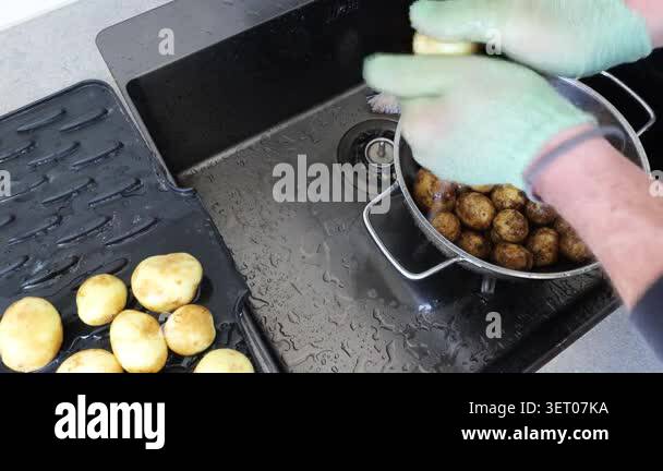 Stockholm, Sweden A man in a residential kitchen uses coarse gloves ...