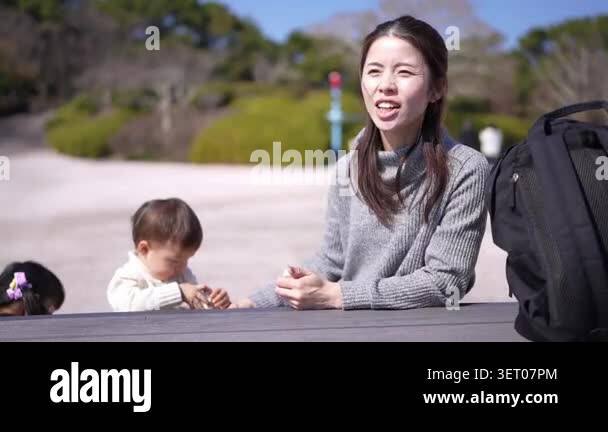 Woman sitting outdoors talking with children Stock Video Footage - Alamy