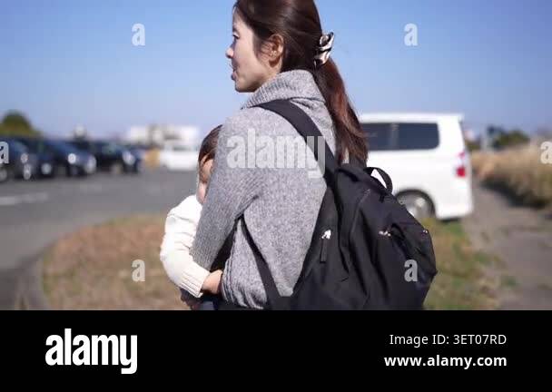 Woman carrying baby walking outdoors with backpack Stock Video Footage ...