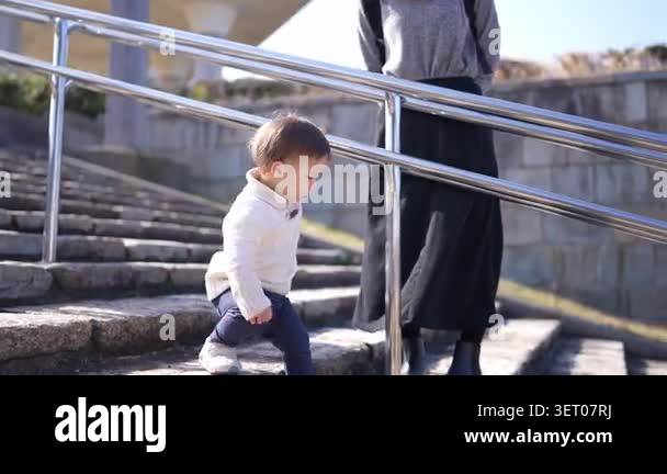 Child walking down stairs while woman stands near Stock Video Footage ...