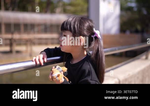 Young girl holding toy looking outside thoughtfully Stock Video Footage ...