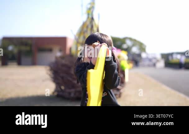 Child holding large yellow object outdoors smiling Stock Video Footage ...