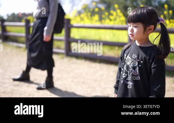 Child standing near adult in sunny field Stock Video Footage - Alamy