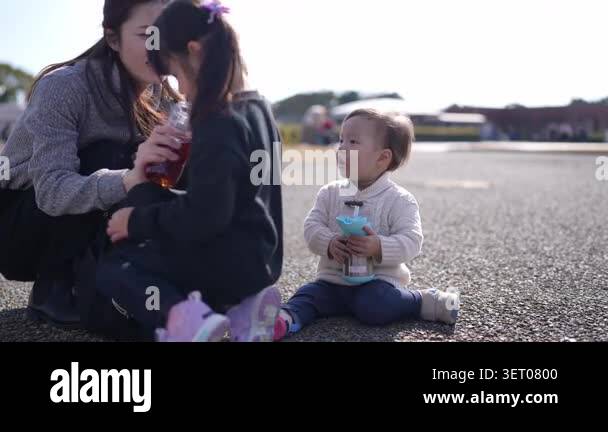 Children sitting outdoors enjoying snacks and drinks Stock Video ...