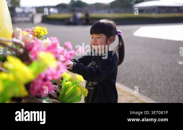 Young girl touching colorful flowers outdoors Stock Video Footage - Alamy