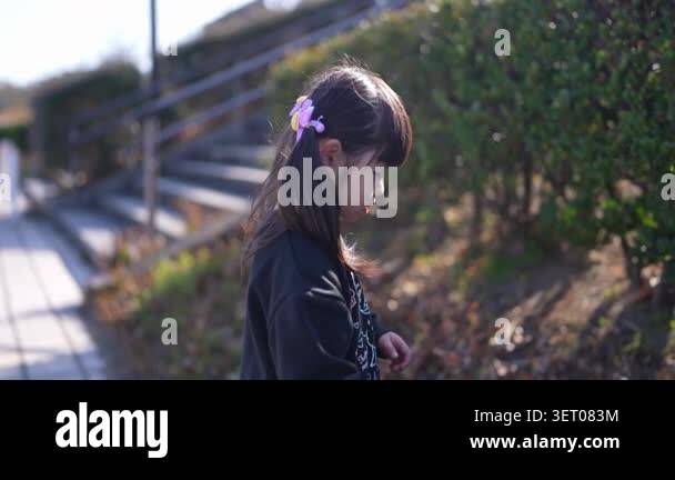 Young girl standing near green bushes Stock Video Footage - Alamy