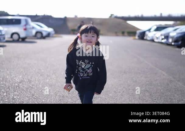 Smiling girl running happily on pavement Stock Video Footage - Alamy