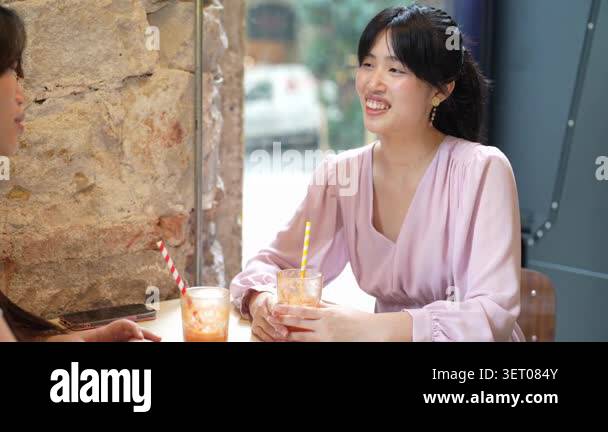 Two women enjoying drinks and chatting together Stock Video Footage - Alamy