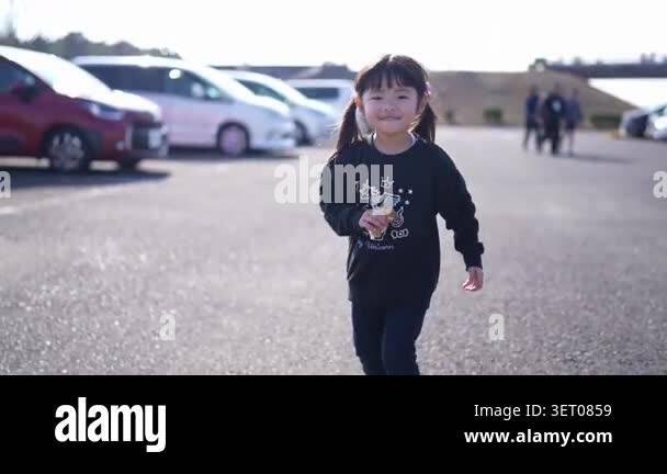 Young girl running happily in parking lot Stock Video Footage - Alamy