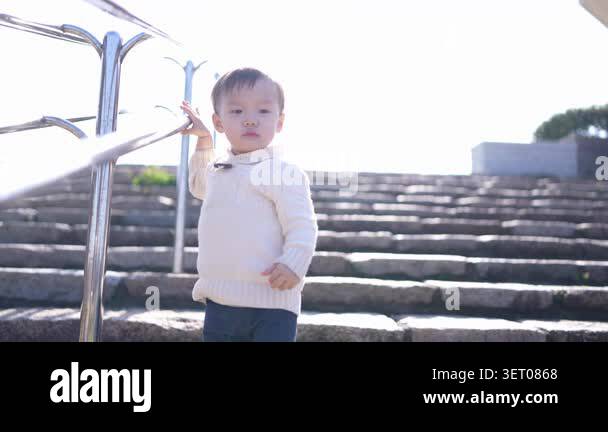 Toddler standing near railing on stone steps Stock Video Footage - Alamy