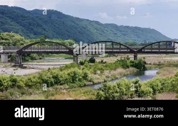 Bridge spanning river surrounded by green hills Stock Video Footage - Alamy