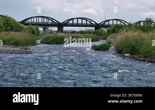 Calm river flowing under bridge Stock Video Footage - Alamy