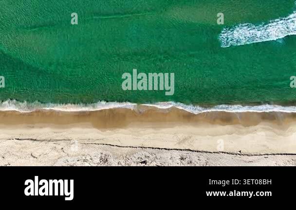 Aerial video beginning with a downward view of the clear turquoise ...