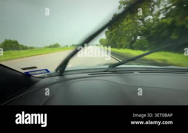 Dashboard view heavy rain with rapid wiper sweeps clearing streaked ...