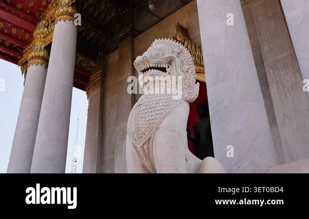 Stone guardian lion at entrance with towering columns and ornate roof ...