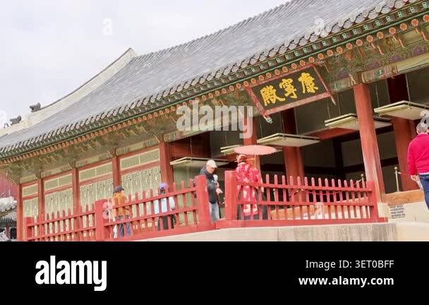Palace facade with asian bride hanbok posing, bright red garment ...