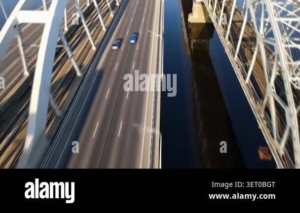 Cars moving on a multi lane highway next to a railway bridge over a ...