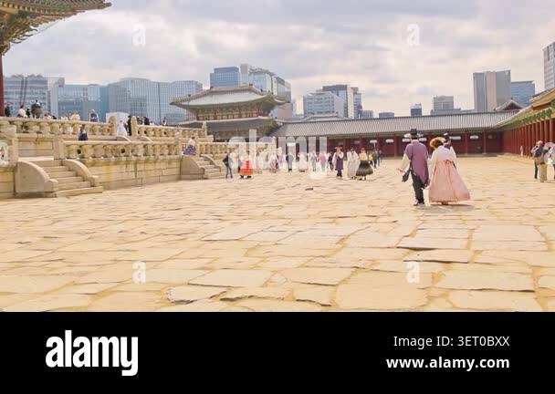 Korean tourists in colorful palace courtyard, lively crowd near ornate ...