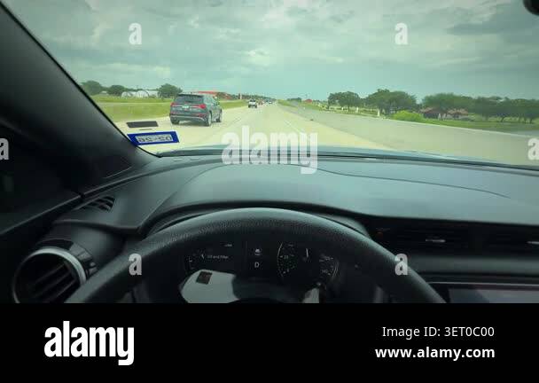 Dashboard view open highway under scattered clouds and distant traffic ...
