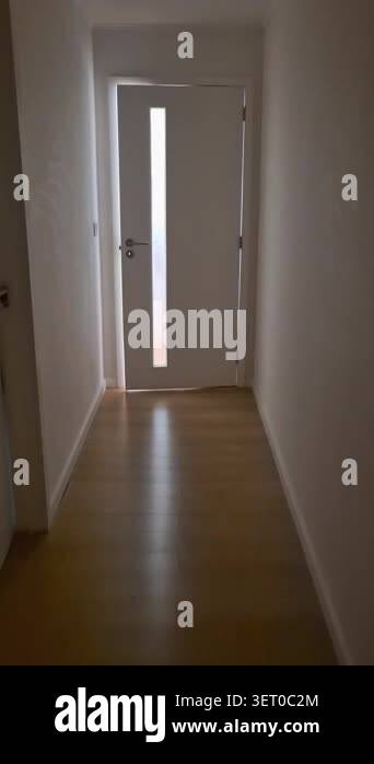 Interior hallway with a partly open door in the distance, light ...
