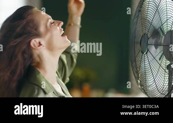 A happy woman with long brown hair, wearing a green shirt, experiences ...