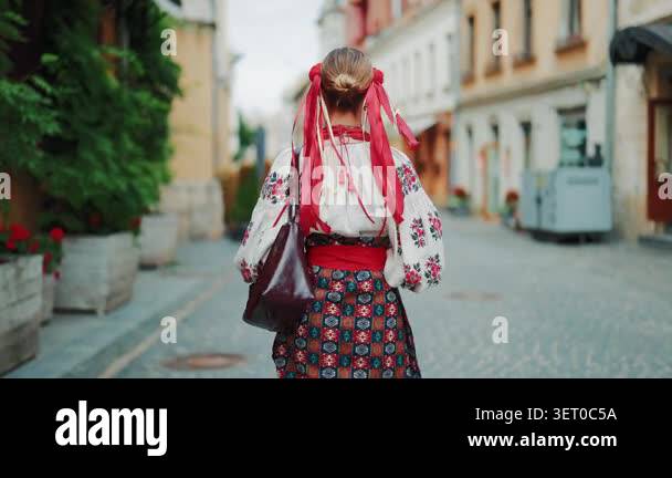Serene woman dressed in traditional Ukrainian vyshyvanka and red wreath ...