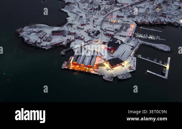 Birds-eye evening shot of a small snow-covered fishing village ...
