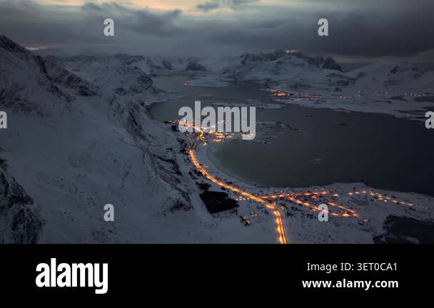 Overhead night panorama of a remote Arctic coastal village nestled ...