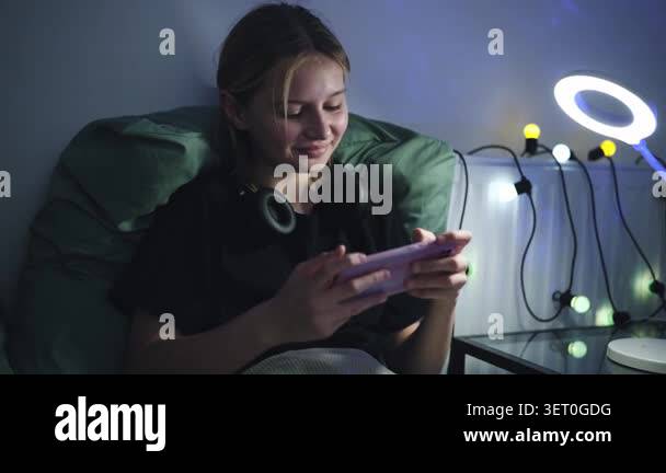 Happy Cute Little Girl Plays A Game On Smartphone In Bed Before Sleep ...