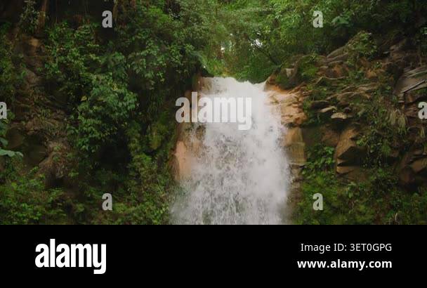 Powerful waterfall falling over rocky cliff in Costa Rica rainforest ...