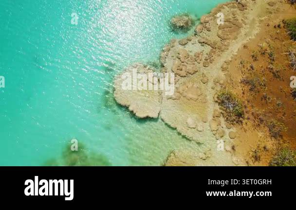 Aerial view of rock formations under turquoise water of Bacalar lake in ...