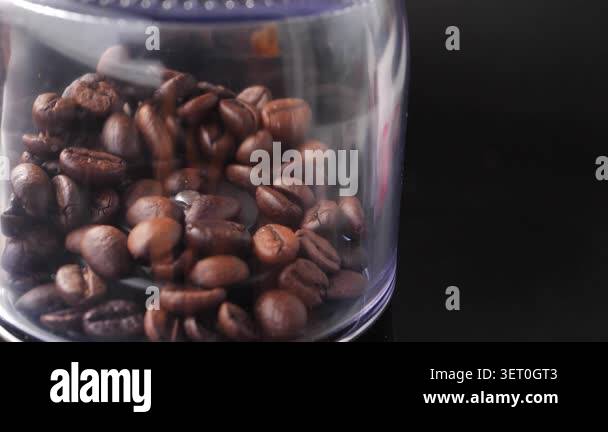 Close-up macro view of roasted coffee beans inside a coffee machine or ...