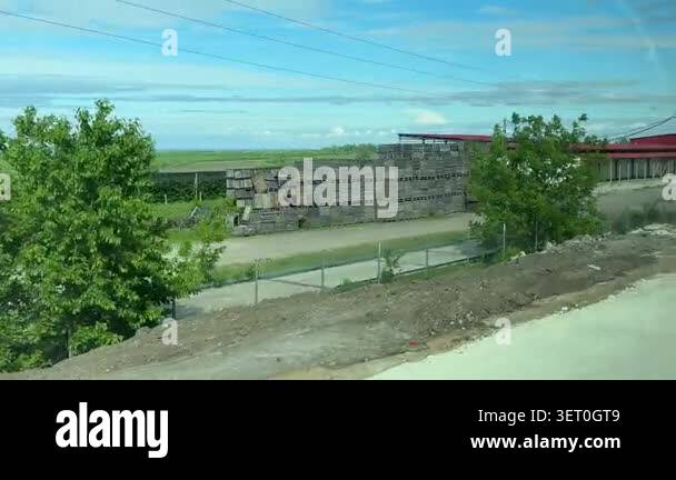 Small white farm building with bright red roof surrounded by stacks of ...