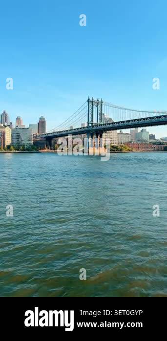 Modern riverboat travels by the East River towards the Manhattan Bridge ...