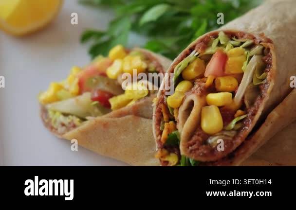 A detailed close up video of a traditional spicy cig kofte wrap cut in ...