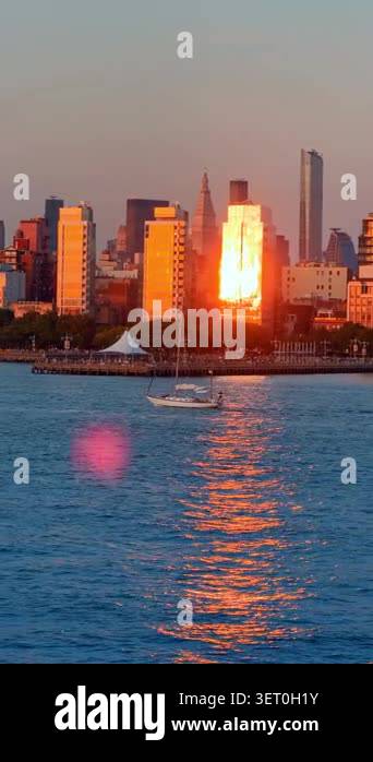 Sunlight dazzles the mirror facade of the high-rise building. Sailboat ...