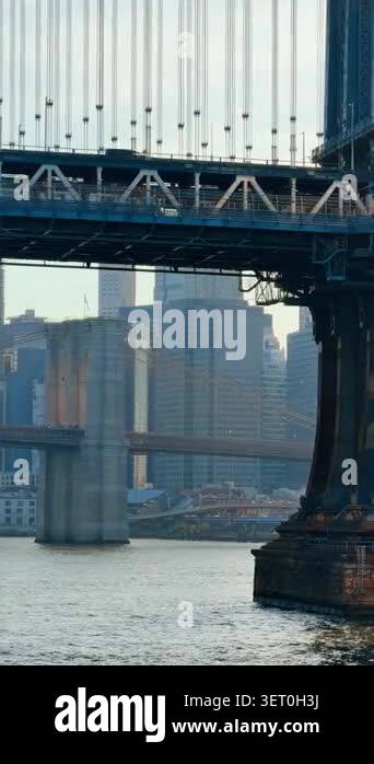 Train moves by the Manhattan Bridge. Low angle view at the famous New ...