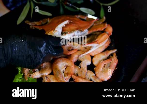 Blue crab and shrimp are boiled in a glass pot, served on a plate and ...