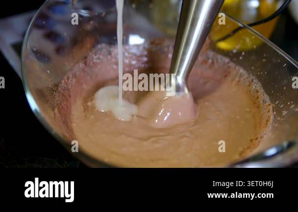 Woman prepares a light cottage cheese dessert with cocoa, milk, gelatin ...