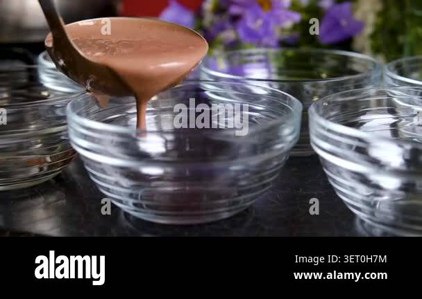 Woman prepares a light cottage cheese dessert with cocoa, milk, gelatin ...