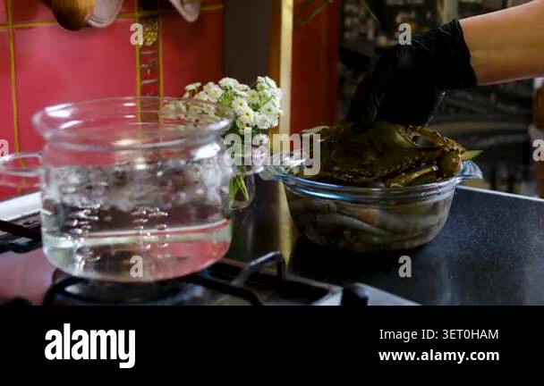 Blue crab and shrimp are boiled in a glass pot, served on a plate and ...