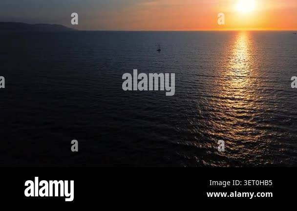 Cinematic 4K aerial drone rotates around a sailboat gliding toward the ...