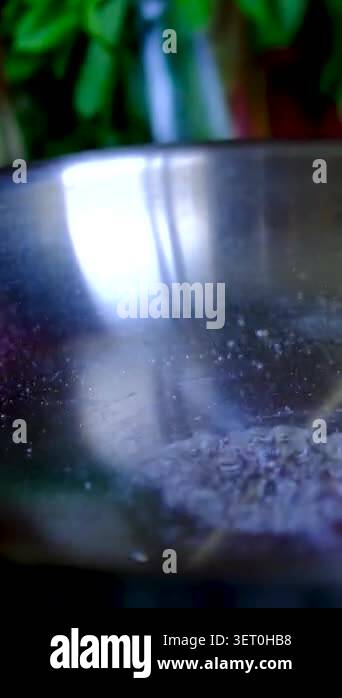 Water drops dance across a hot stainless steel pan to test cooking ...