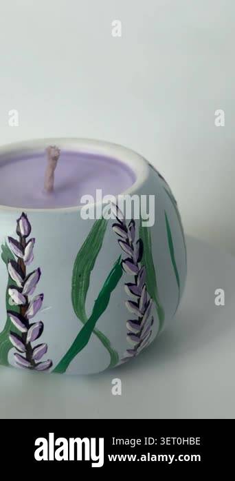 Scented soy wax candle with hand-painted lavender on plaster pot, macro ...