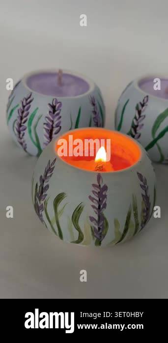 Burning lavender scented soy candle close up, panning shot of handmade ...