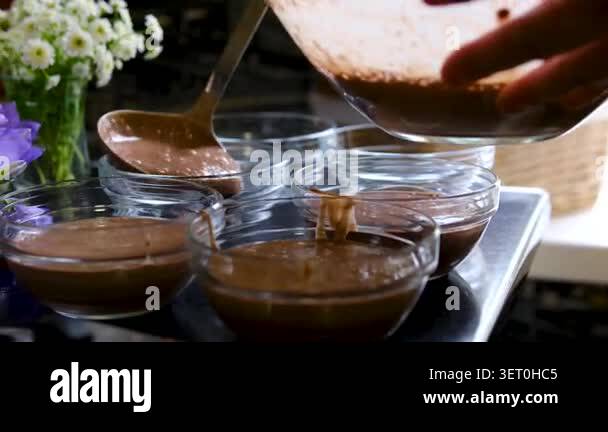 Woman prepares a light cottage cheese dessert with cocoa, milk, gelatin ...