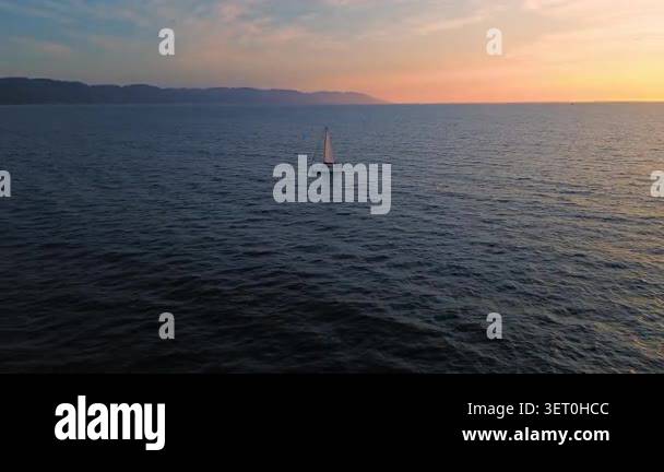 Cinematic 4K aerial drone rotates around a sailboat gliding toward the ...