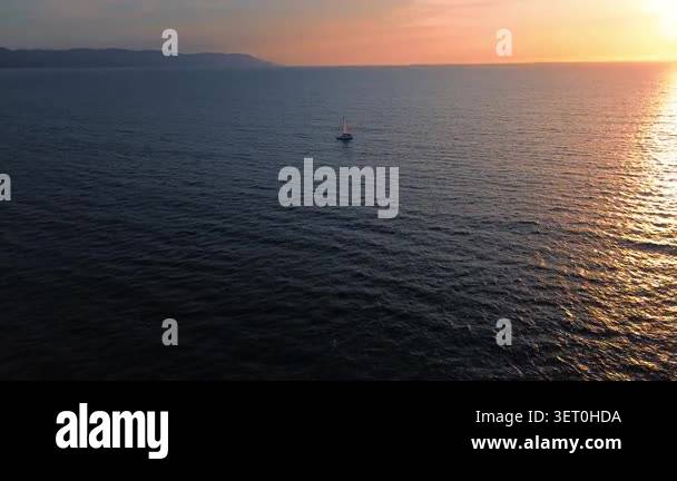 Cinematic 4K aerial drone rotates around a sailboat gliding toward the ...