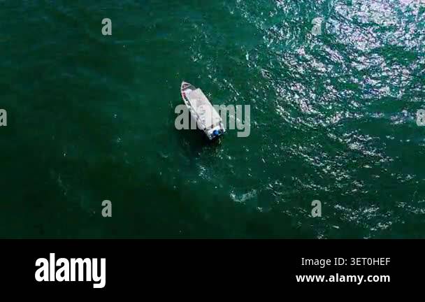 Aerial near-zenith drone captures a small boat moving serenely through ...